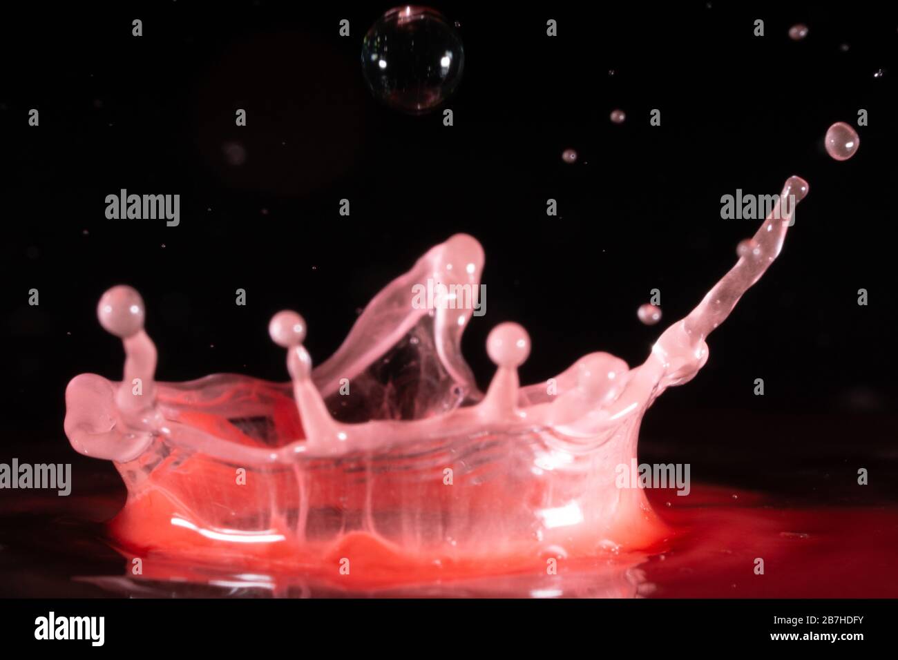 Red liquid ink splash on black background Stock Photo - Alamy