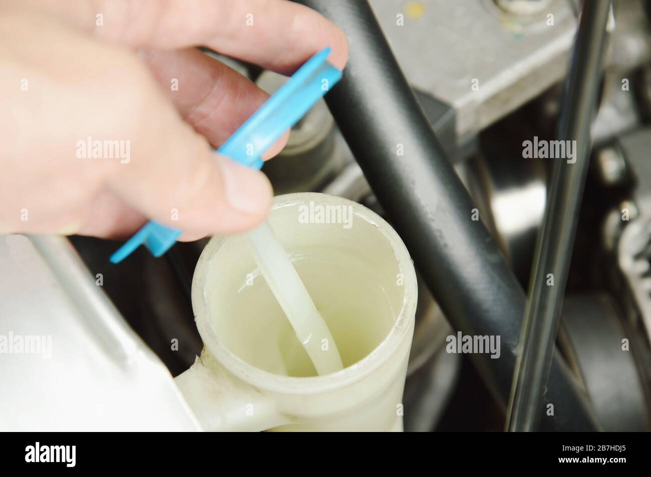 hand open cover of water tanker for car windshield wiper and checking ...