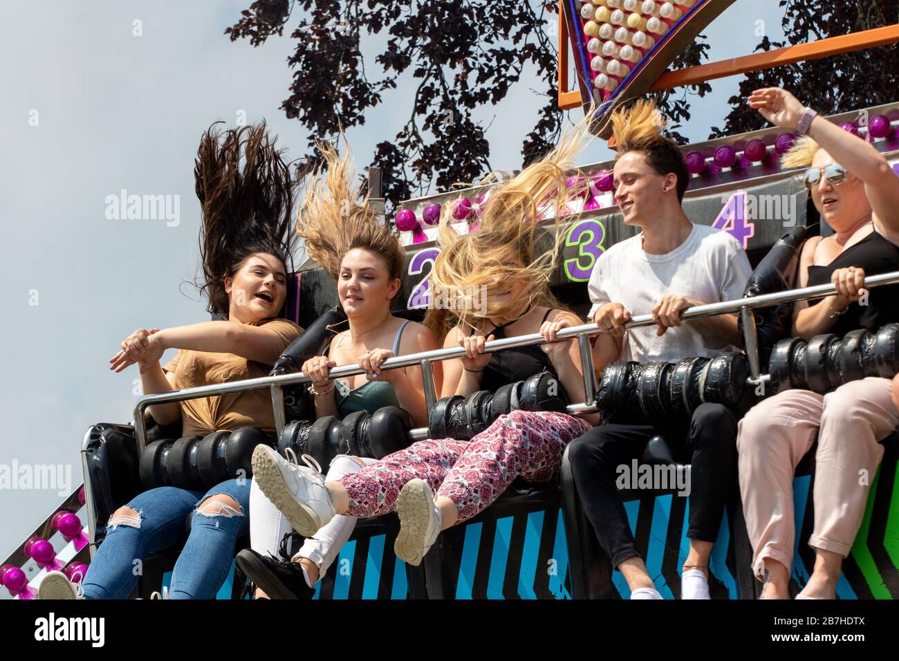 The flying hair of teenage girls on a fun fair ride Stock Photo - Alamy