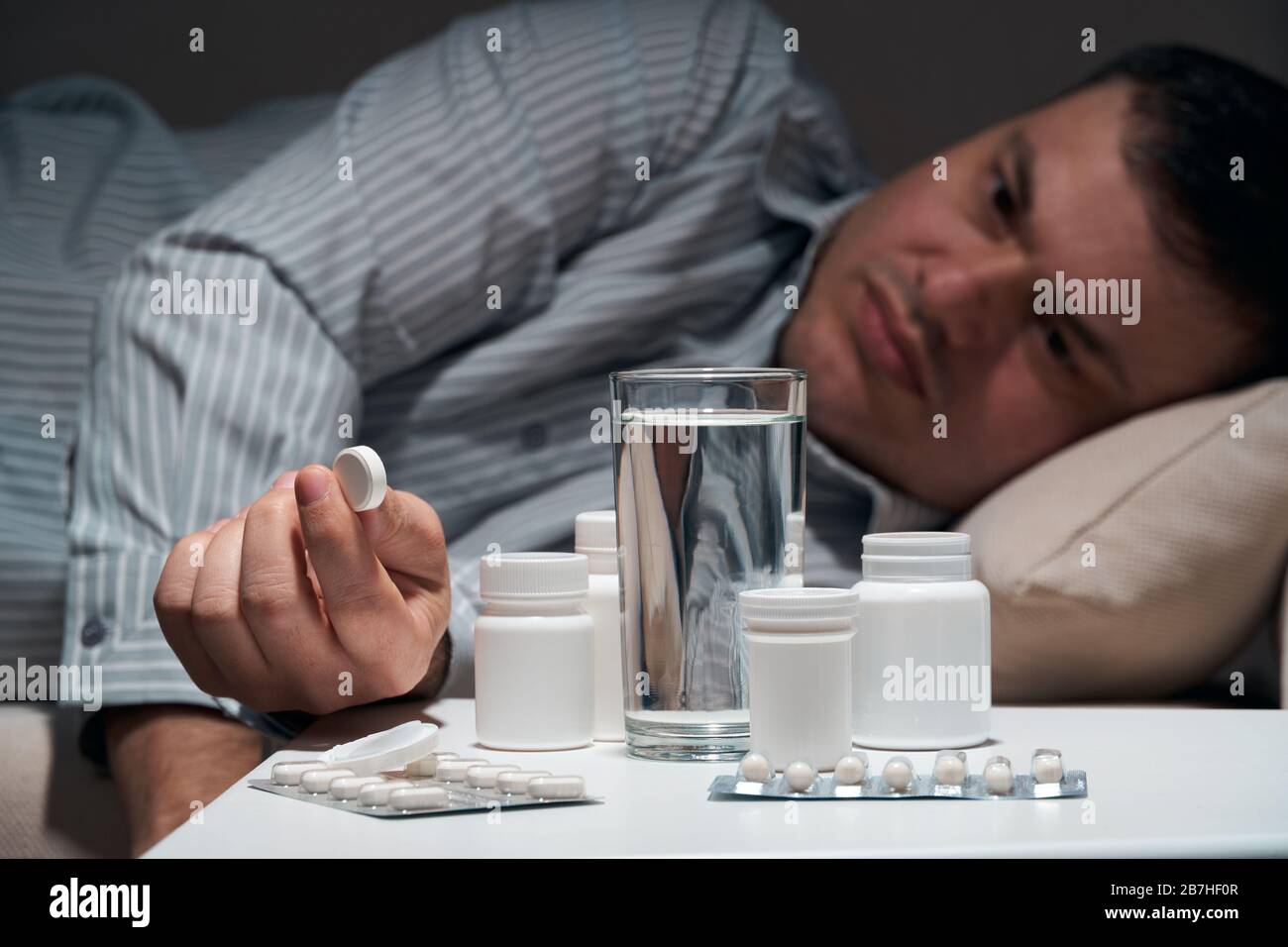 Overworked businessman is lying on the sofa and resting. Pills and ...