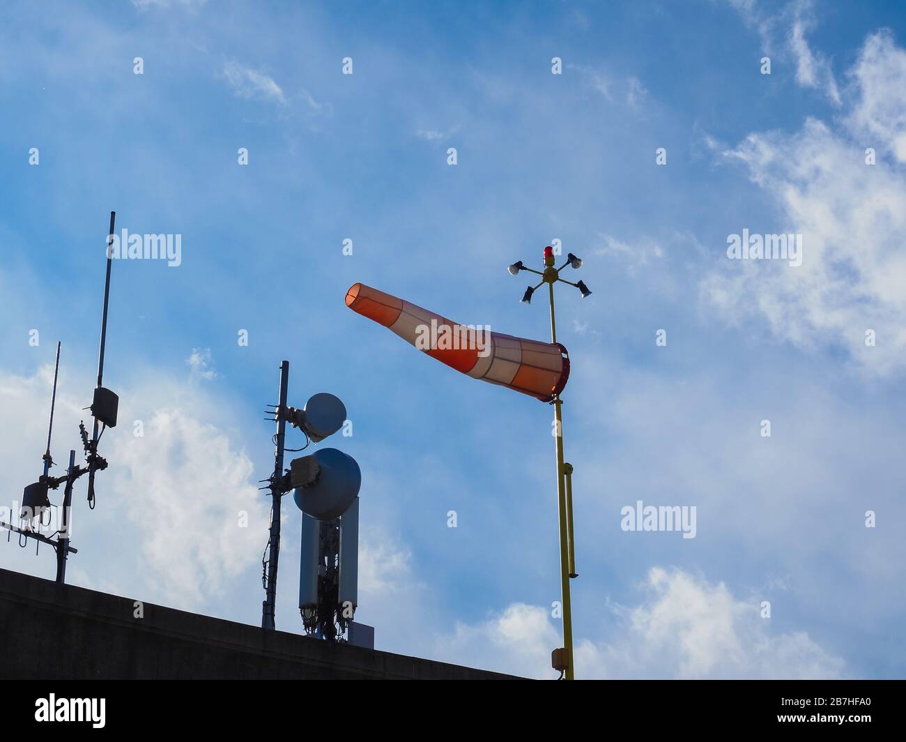 windsock and aerials over blue sky with clouds Stock Photo - Alamy