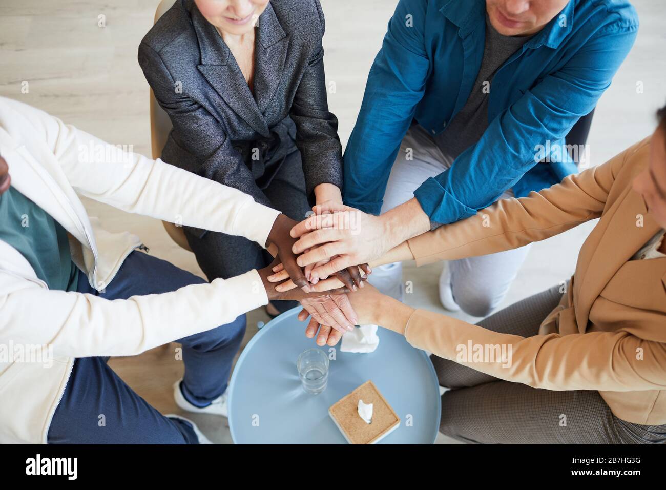Above view at multi-ethnic group of people stacking hands while ...
