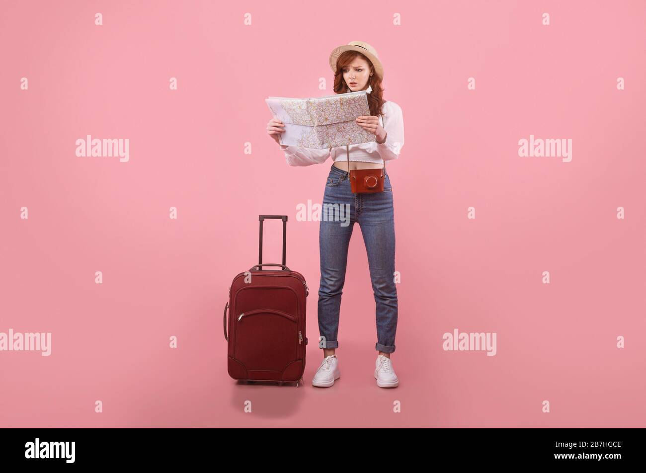 Confused Girl Looking At Map Standing With Suitcase, Studio Shot Stock ...