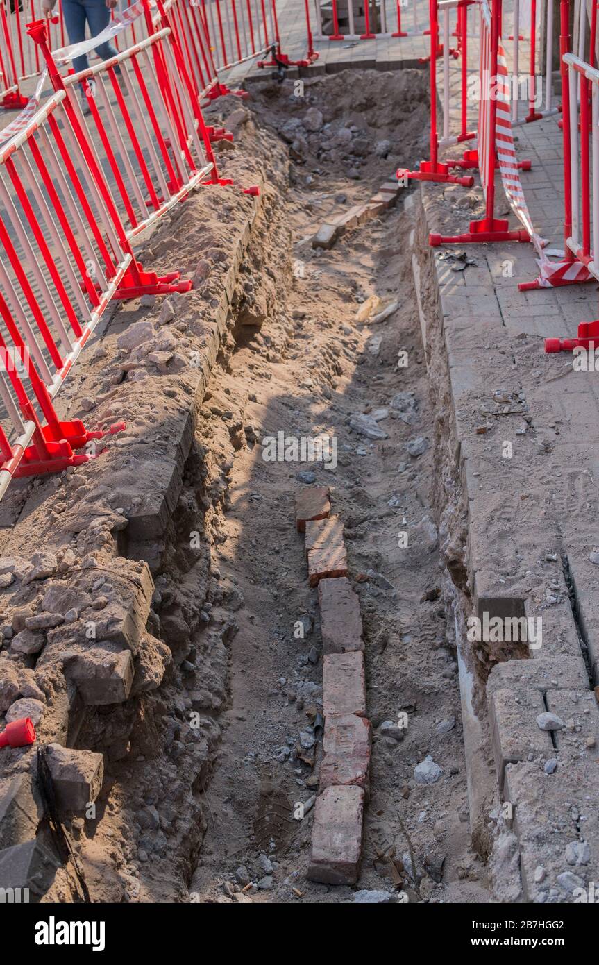 Danger for pedestrians on the street. A pit on the sidewalk, surrounded ...