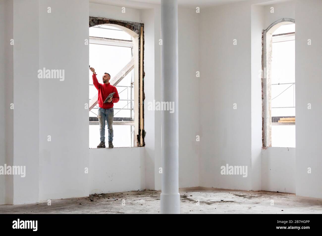 Worker balancing on a window while working. Building site Stock Photo ...