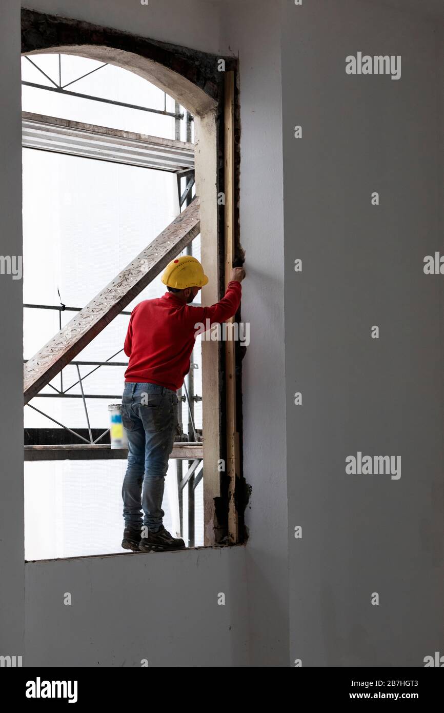 Worker balancing on a window while working. Building site Stock Photo ...