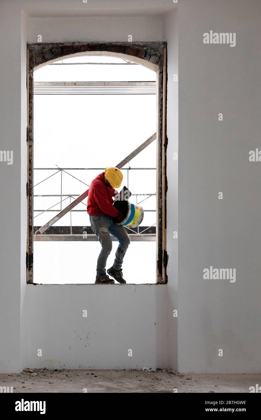 Worker balancing on a window while working. Building site Stock Photo ...