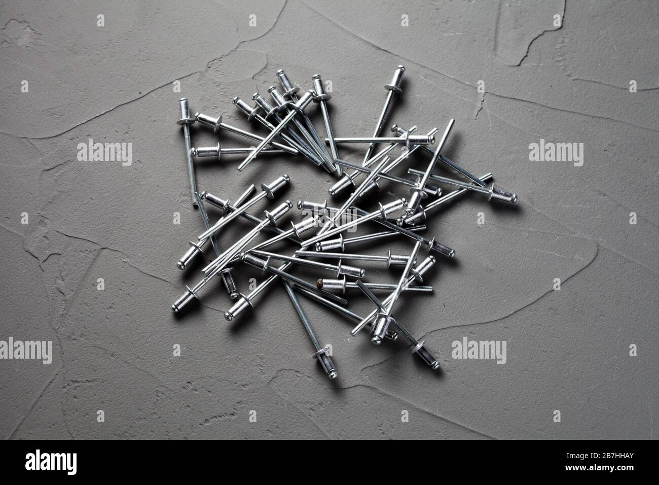 metal rivets on concrete background Stock Photo - Alamy