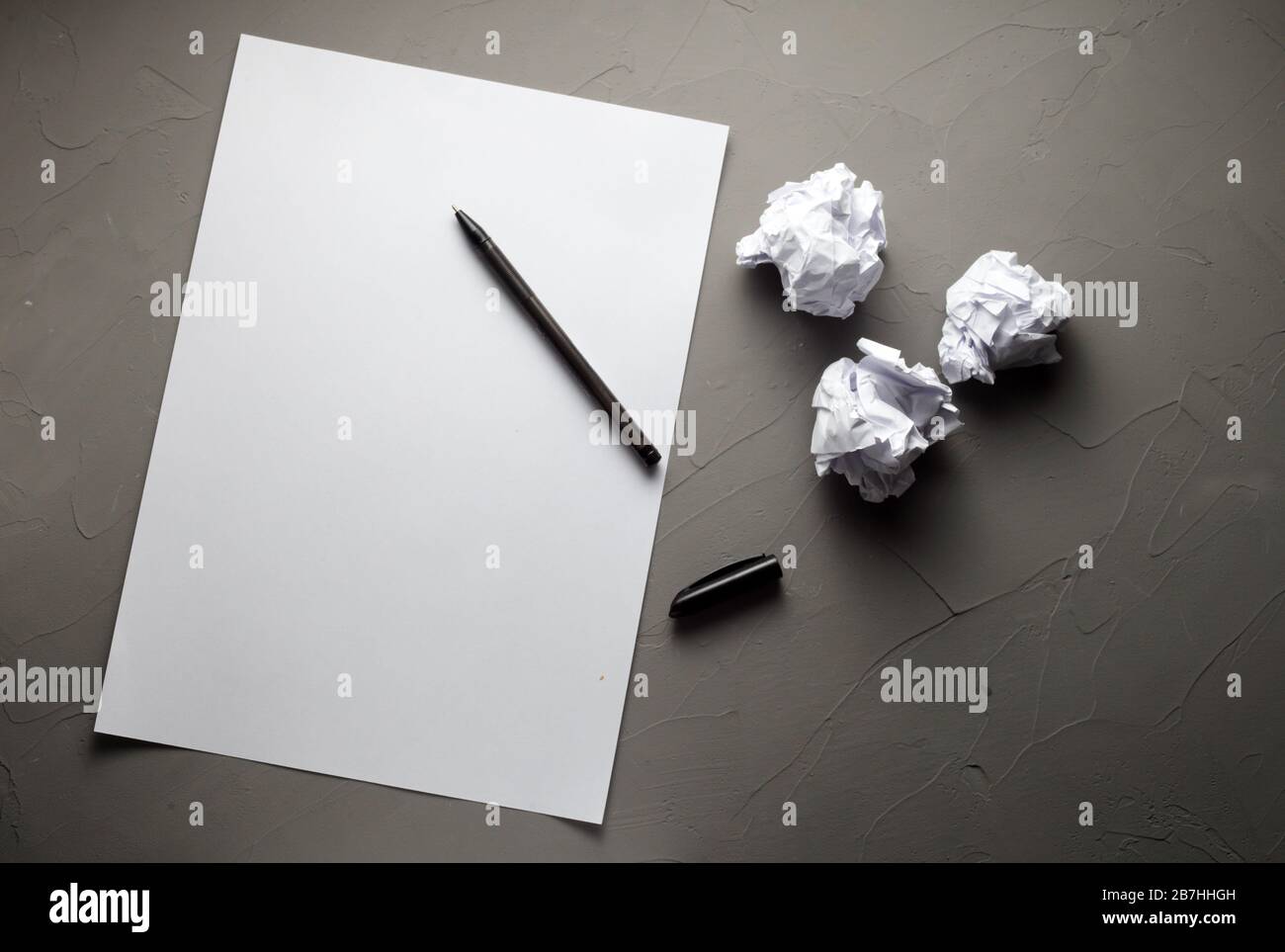 blank white paper, pen for writing and three crumpled sheets of paper ...