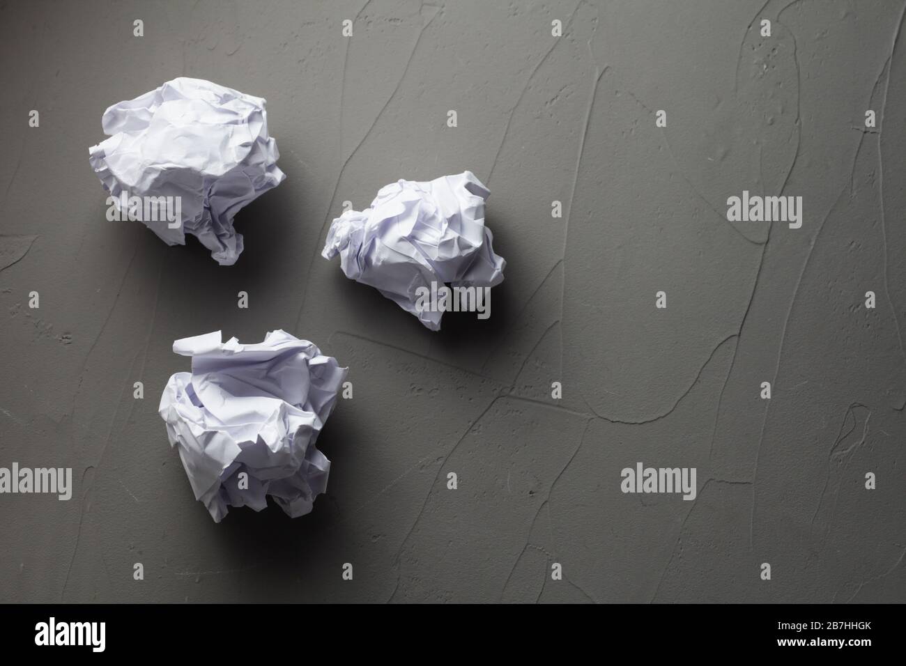 three crumpled sheets of paper on a concrete background with a place ...