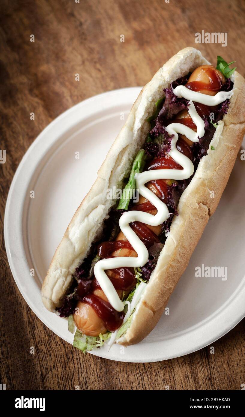 classic hot dog with frankfurter sausage and sauces on wood table Stock ...