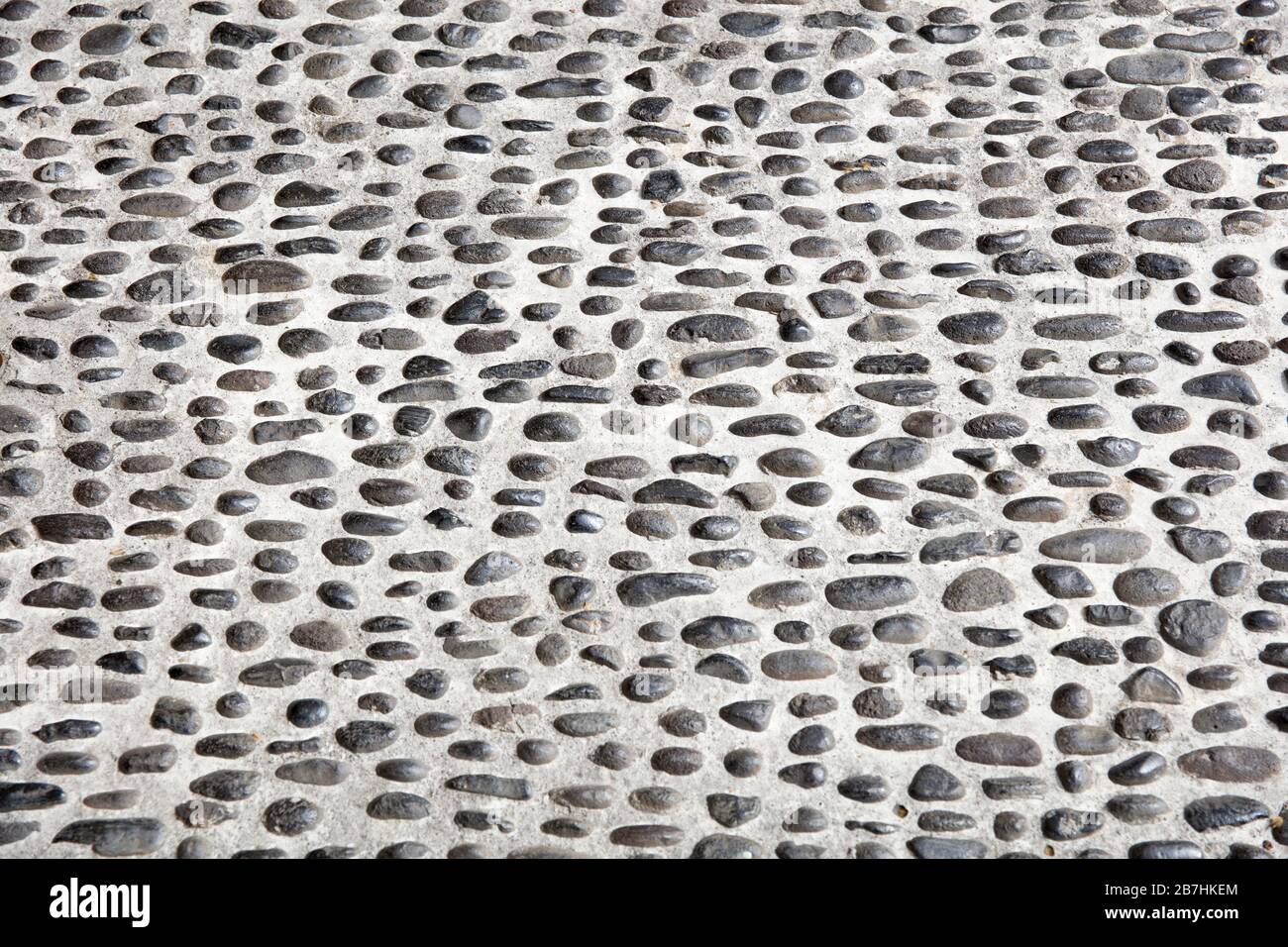 Closeup of the cobbled pavement made of rounded pebbles Stock Photo - Alamy