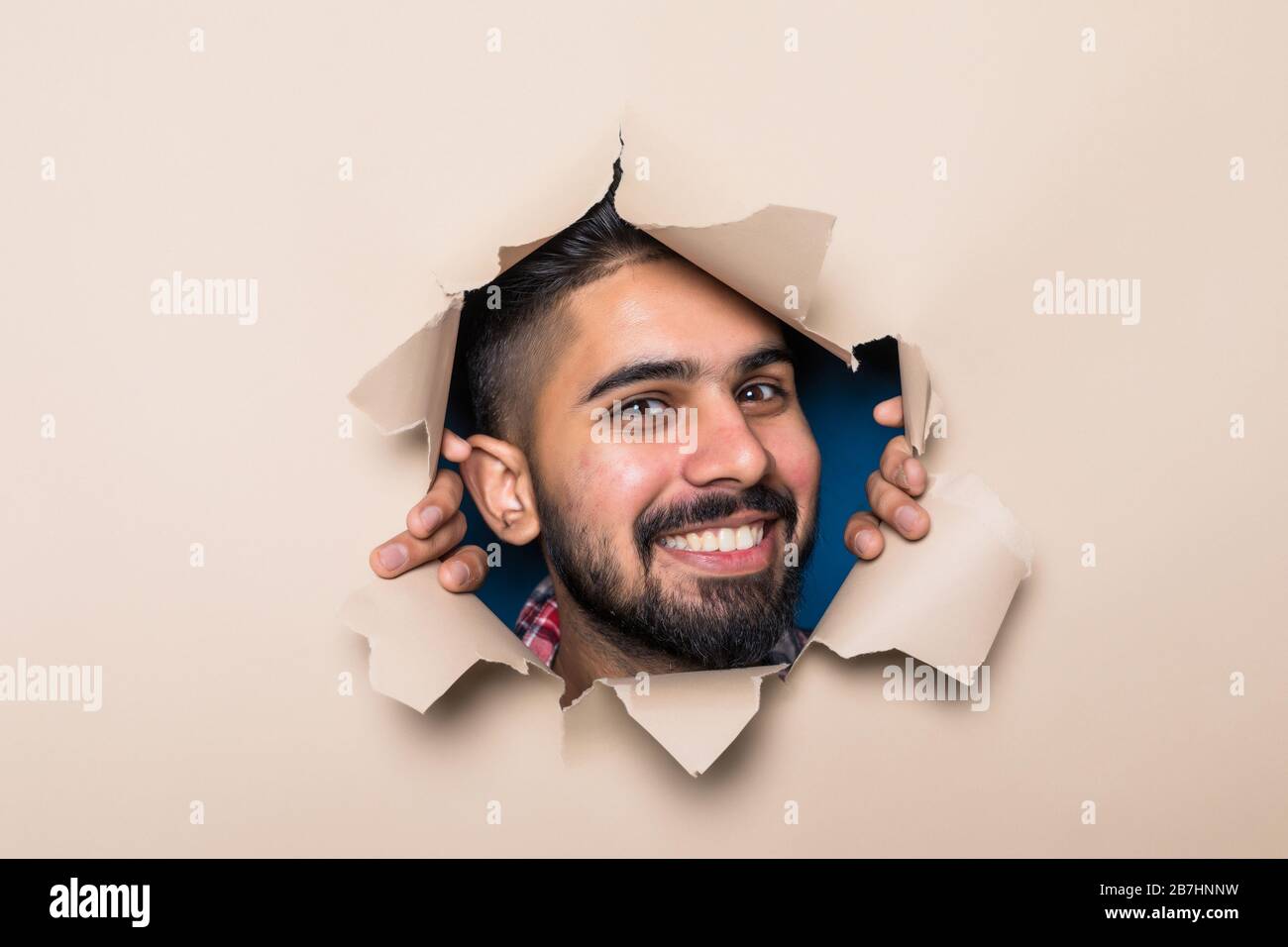 Man peeking through torn paper hi-res stock photography and images - Alamy