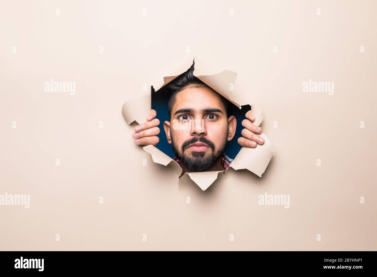 Man looking through ripped paper hole hi-res stock photography and ...