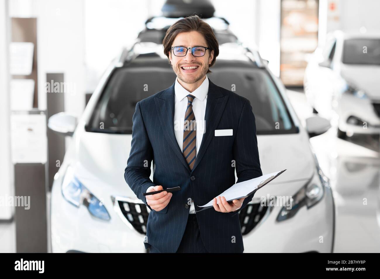 Salesman Standing In Dealership Center With Document Stock Photo - Alamy