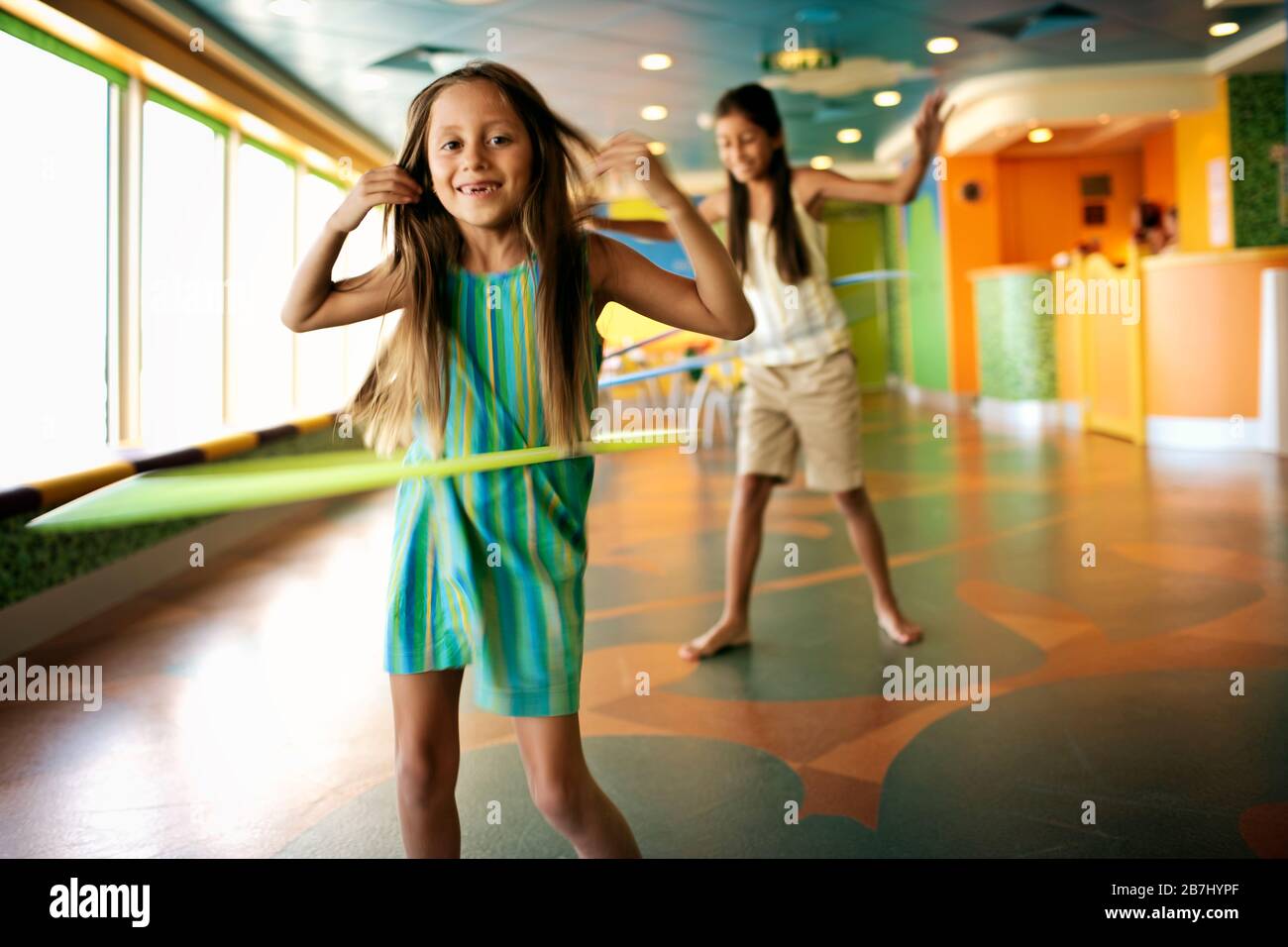 Two young sisters hula hooping Stock Photo - Alamy