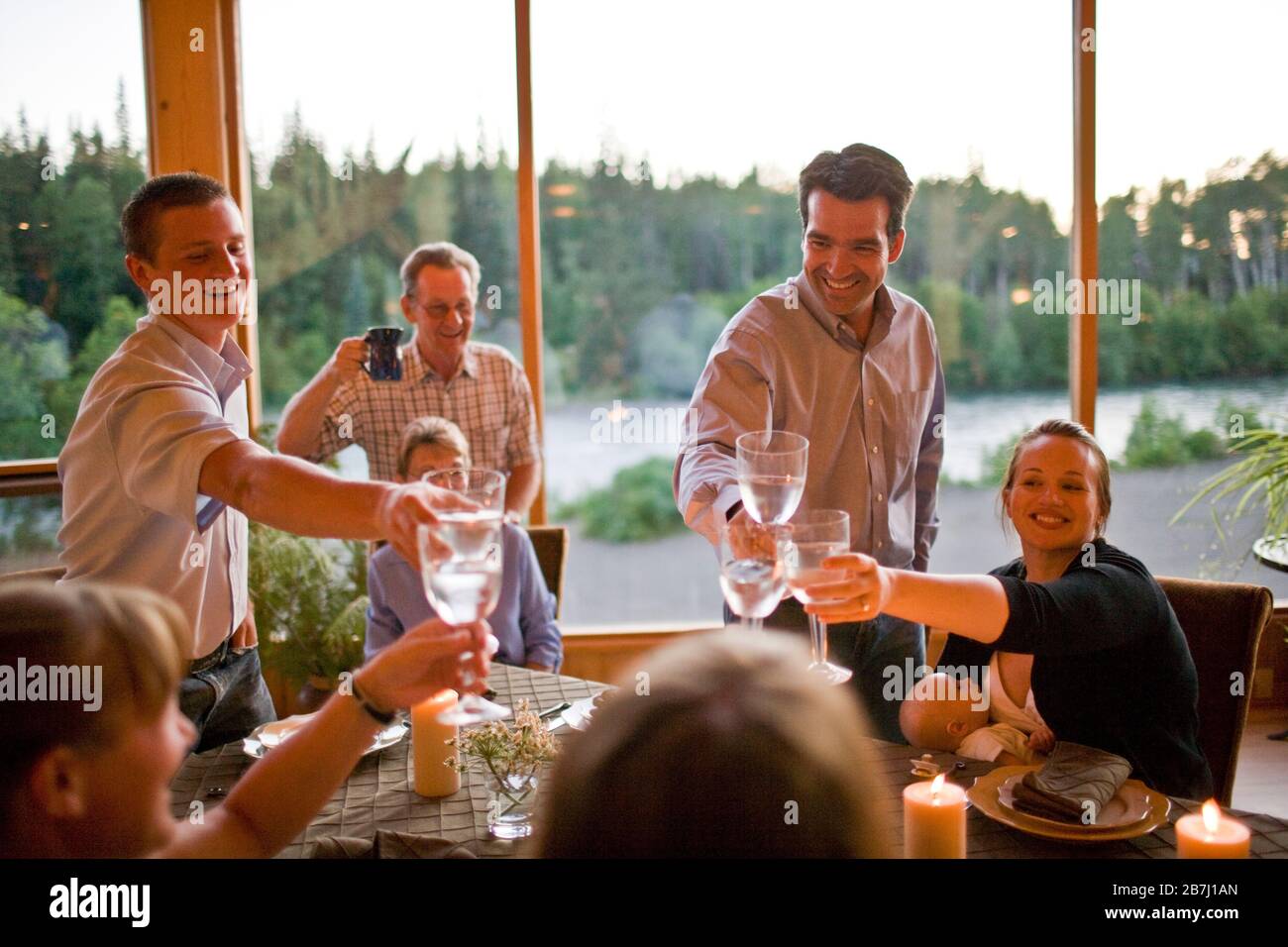 Family toasting at dinner table Stock Photo - Alamy