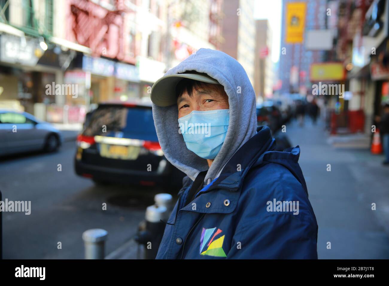 People wear face masks as they walk along the quiet streets of ...