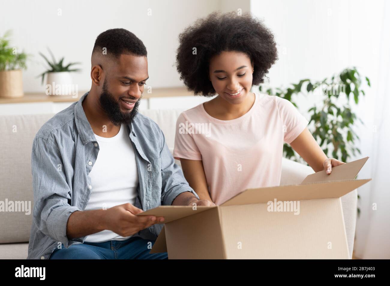 Quick purchases in online store. Couple opens box Stock Photo - Alamy