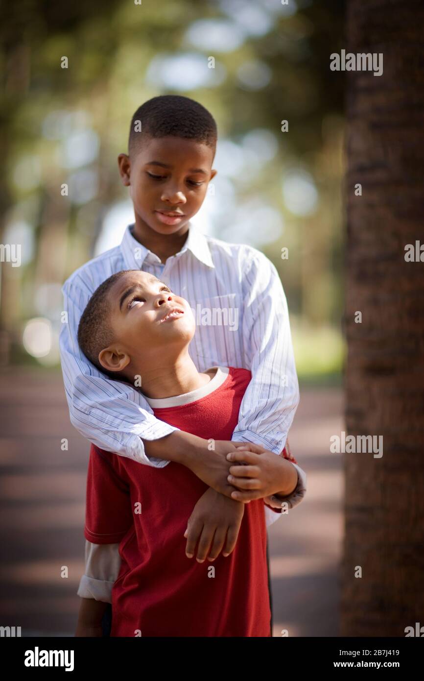 Young boy looking up to his older brother Stock Photo - Alamy