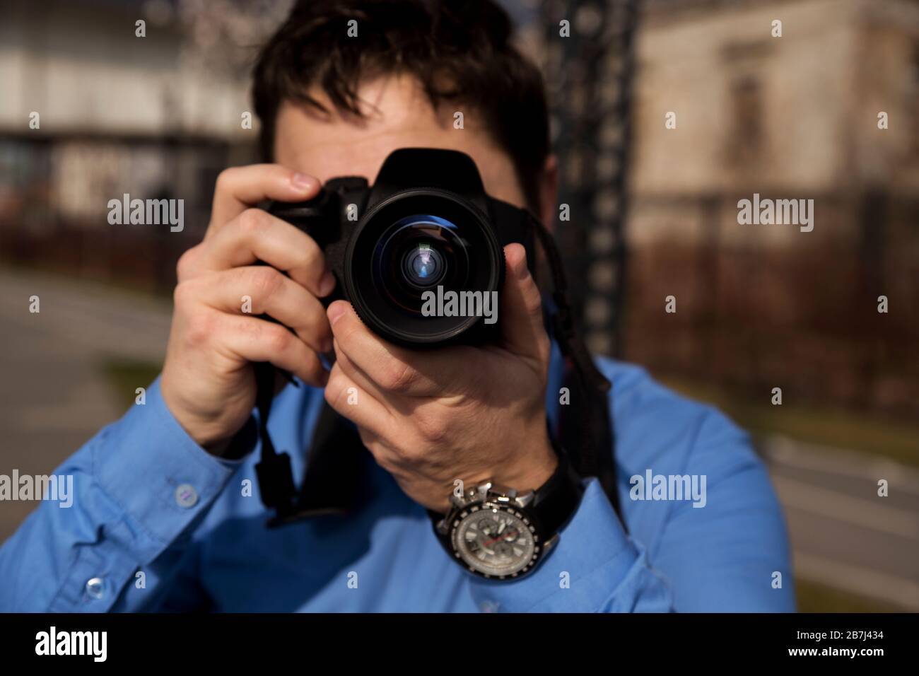 Photographer photographing outdoors. Shooting in urban city environment ...