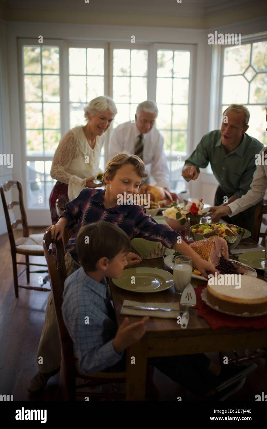 Happy family gathered around a dining table on Christmas day Stock ...
