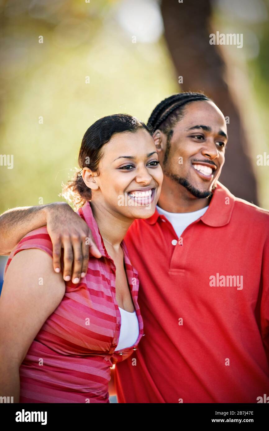 Young adult couple hugging while outside Stock Photo - Alamy