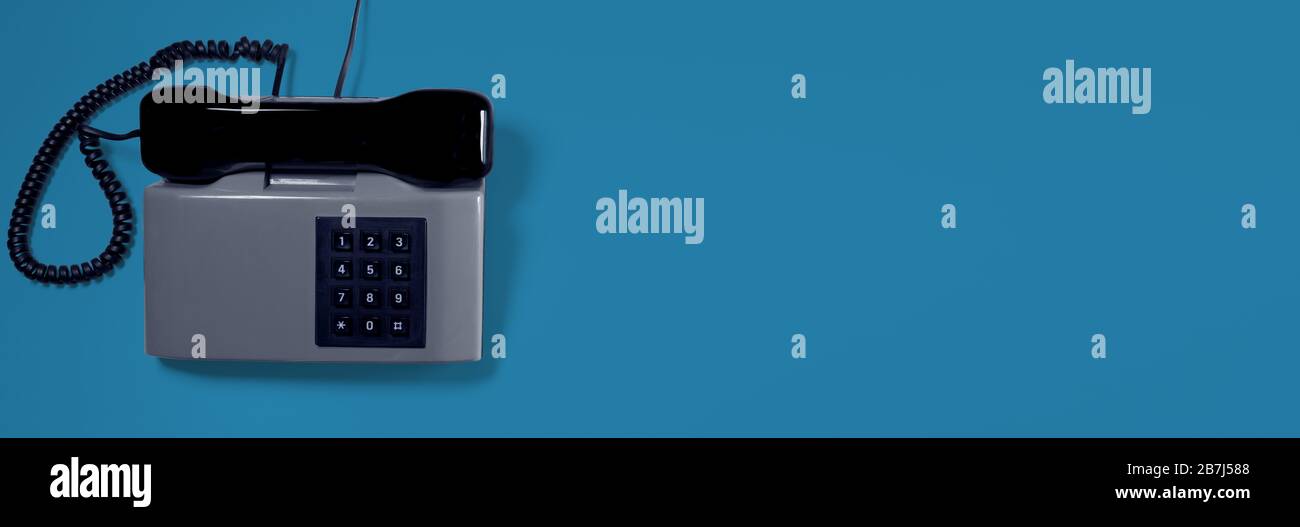A grey vintage telephone with blue background Stock Photo - Alamy