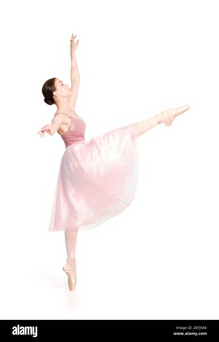 Elegant woman in a pink skirt and beige top dancing ballet. Studio ...