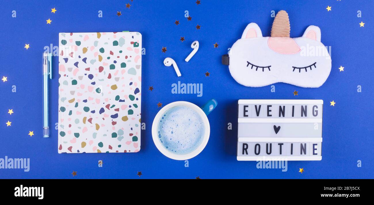 A mask for sleeping, a diary for notes and a cup of matches on a blue ...