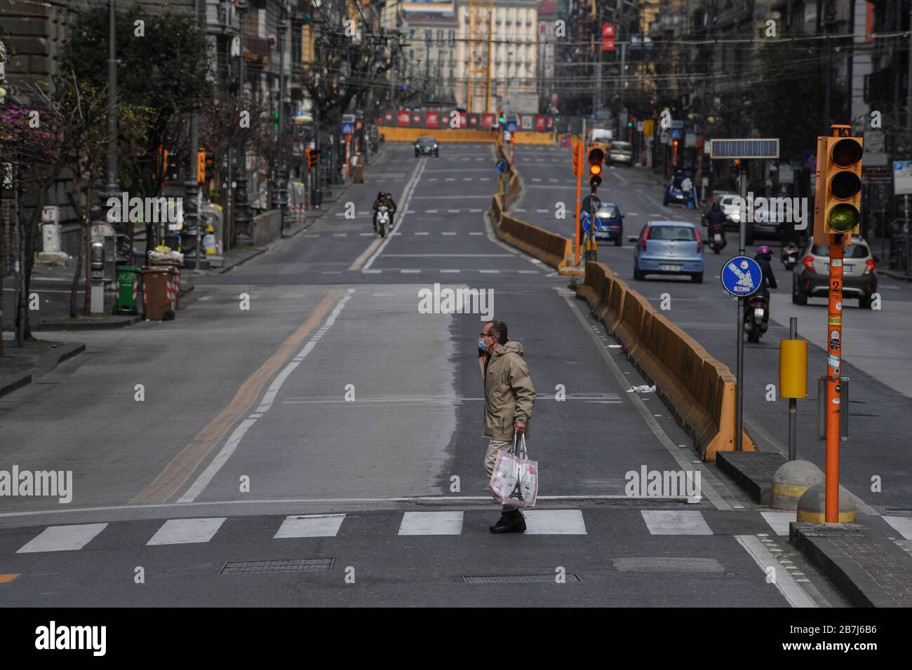 Naples, Italy. 16th March 2020. Man wearing a protective mask walks in ...