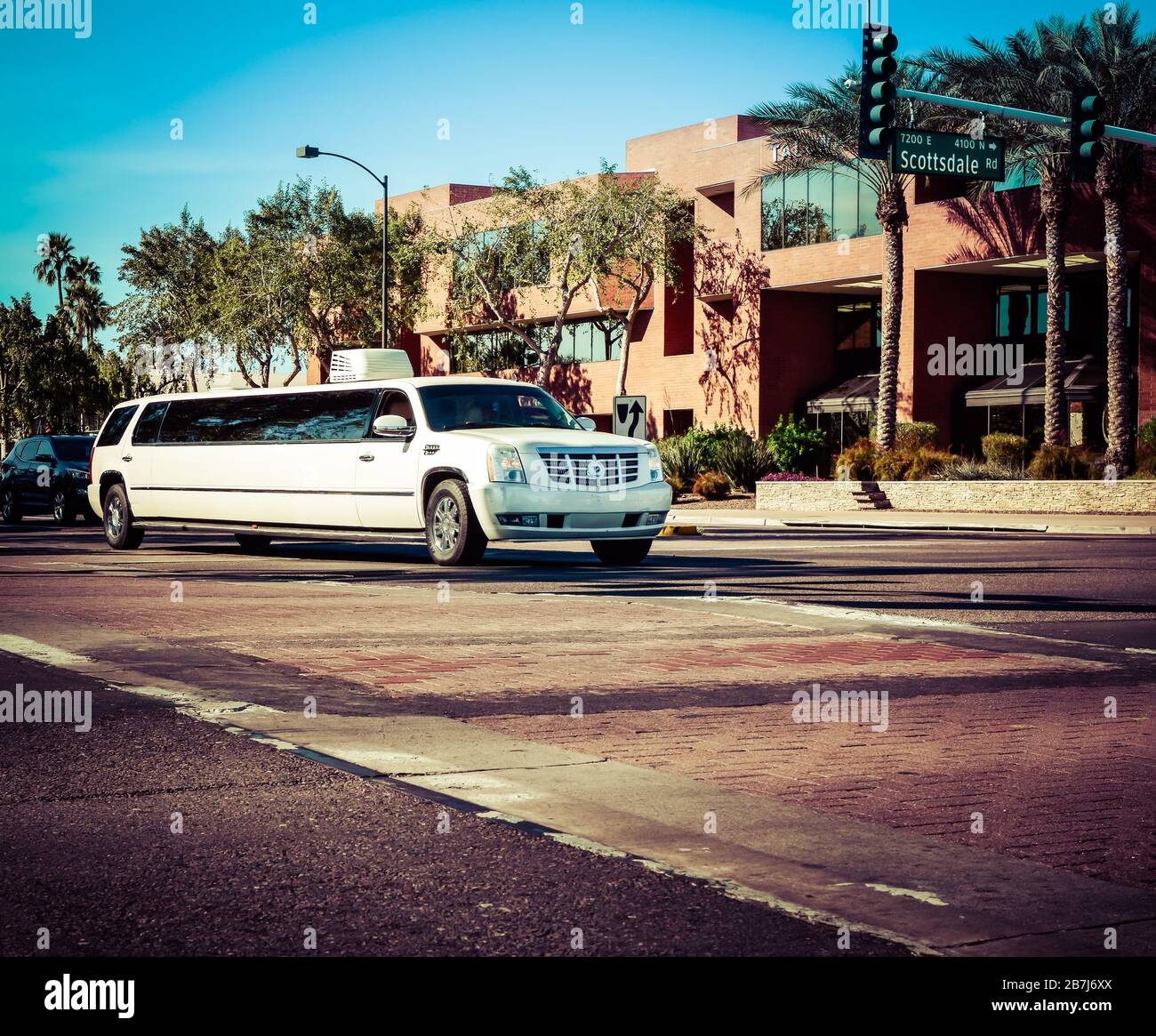 A white Cadillac stretch limousine, crossing an intersection at ...