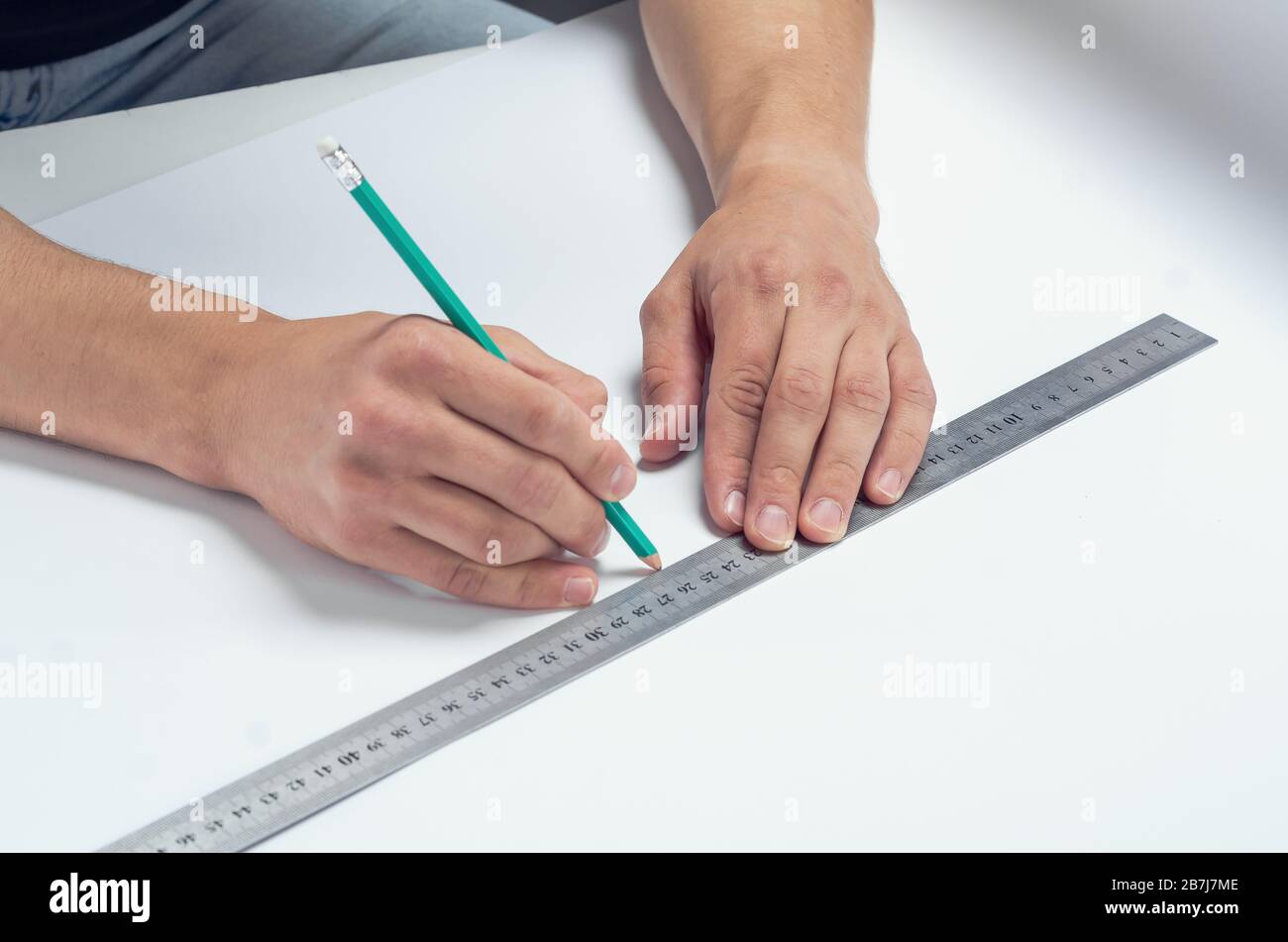 Male hand draws pencil under a ruler on a white sheet of paper Stock ...