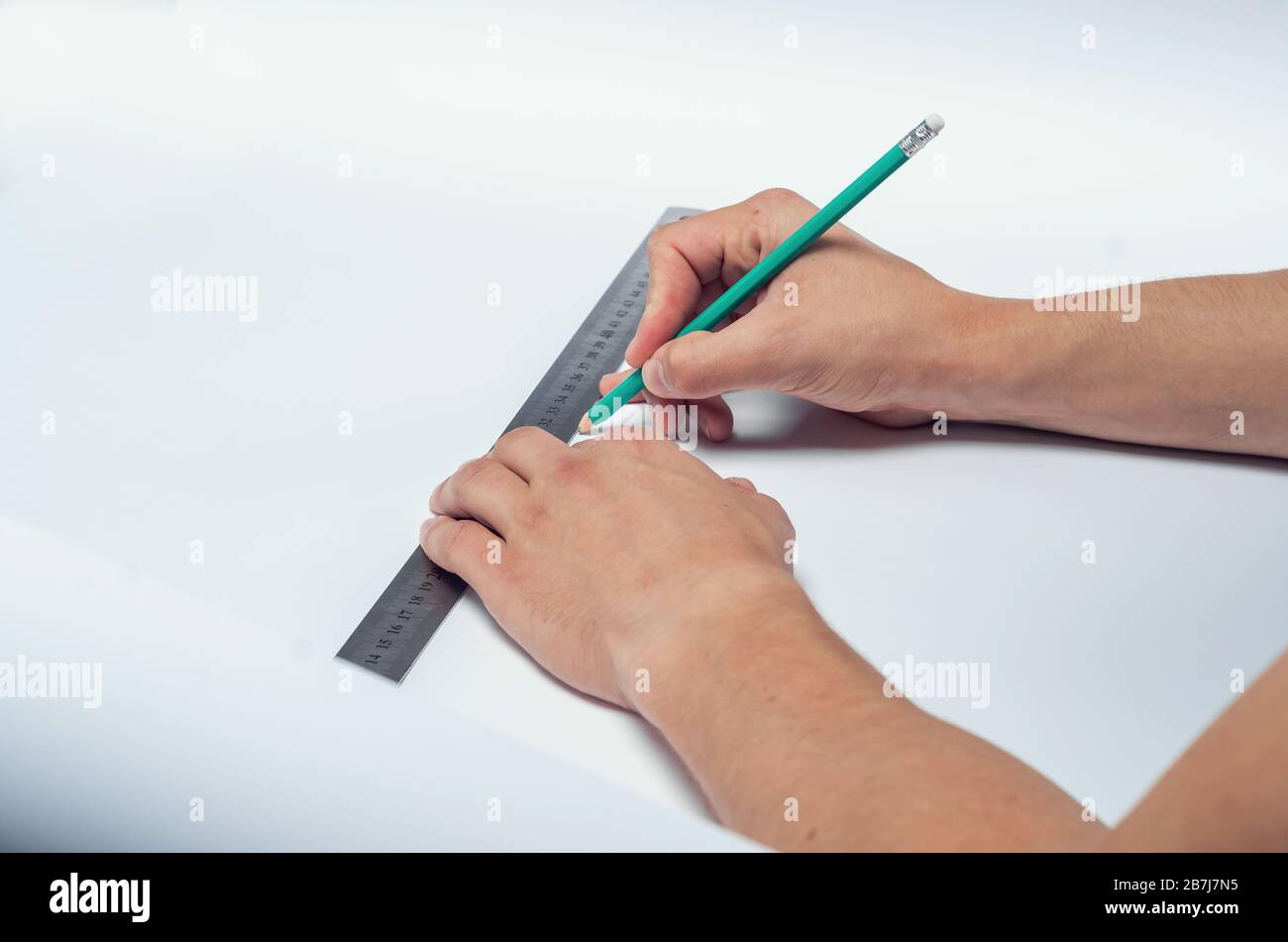 Male hand draws pencil under a ruler on a white sheet of paper Stock ...