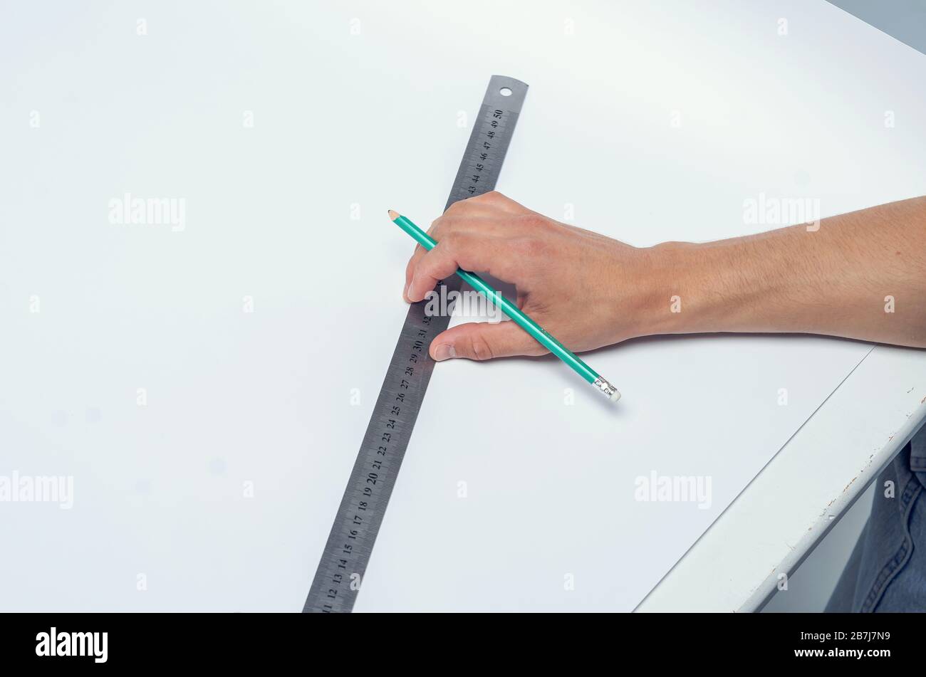 Male hand draws pencil under a ruler on a white sheet of paper Stock ...