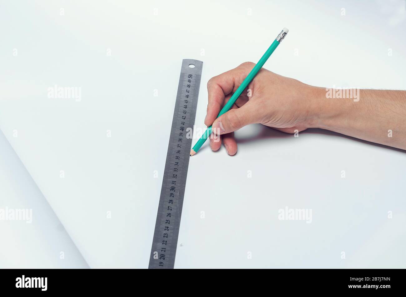 Male hand draws pencil under a ruler on a white sheet of paper Stock ...