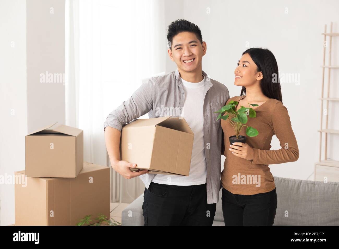 Happy asian family enjoying their moving day Stock Photo - Alamy