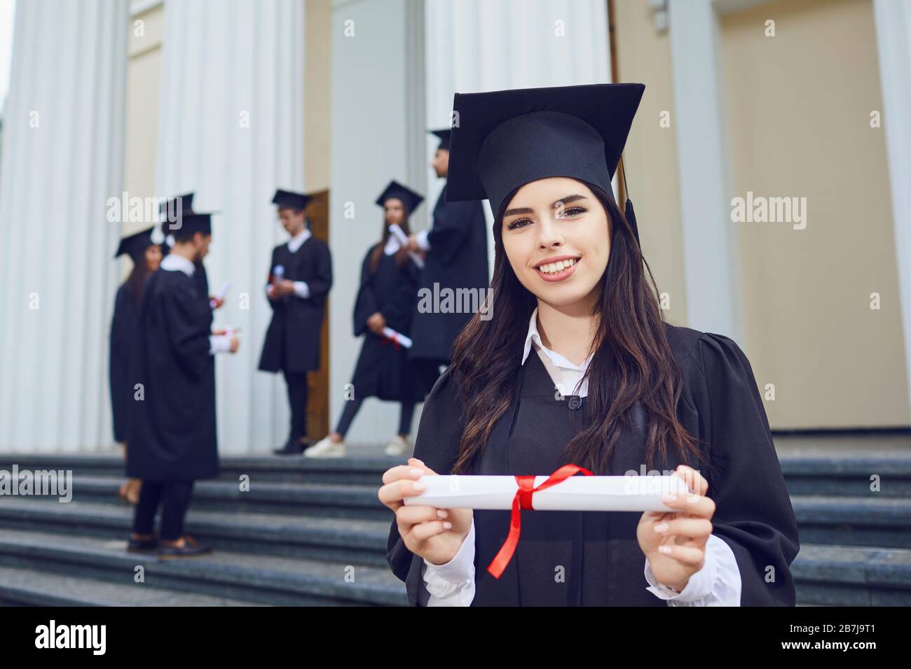 A girl graduate against the background of university graduates Stock ...