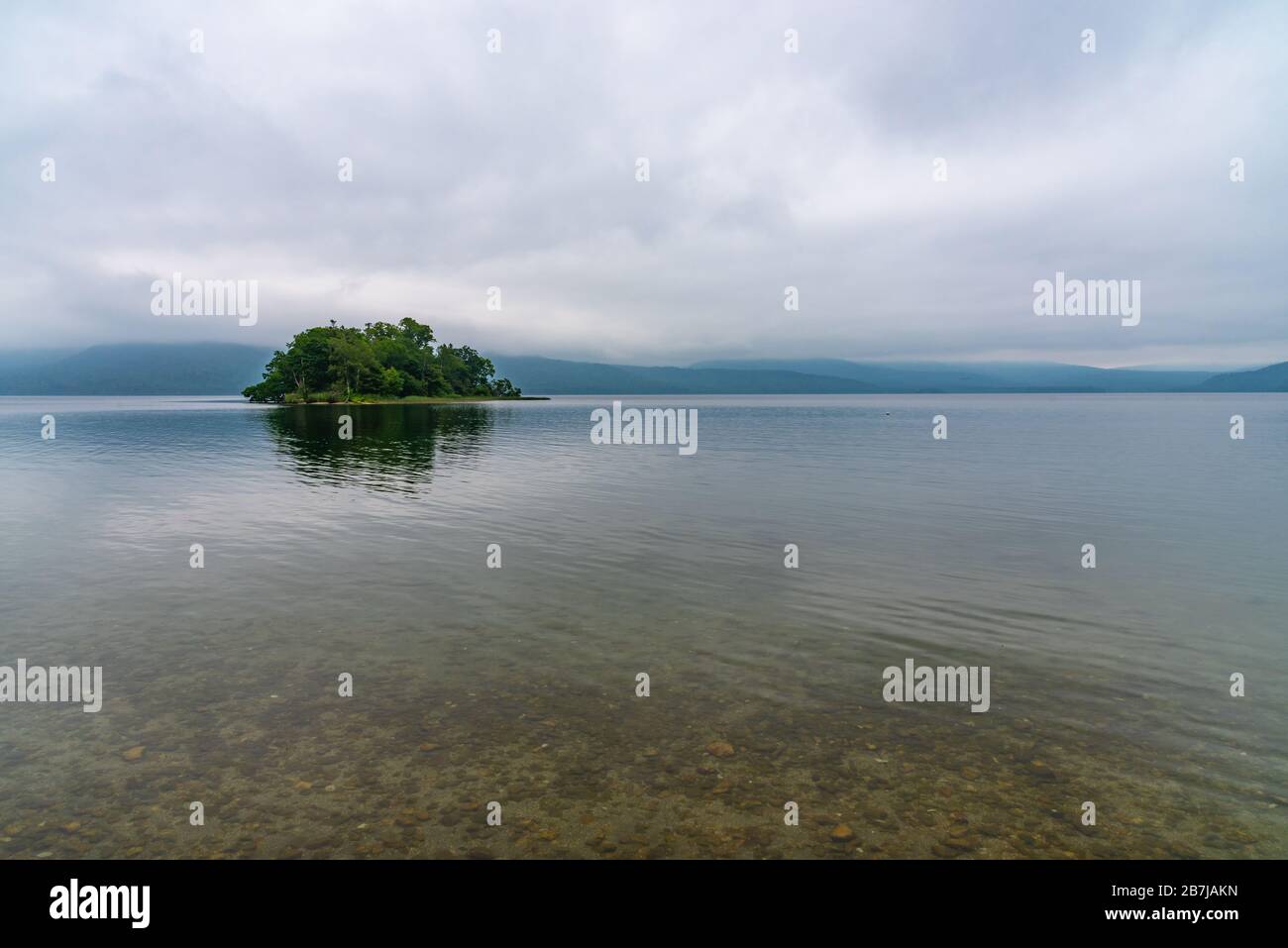 One small island on a water surface Stock Photo - Alamy