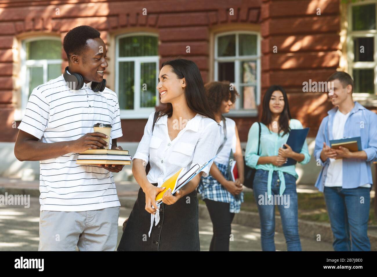 Student couple having break after study, talking and flirting outdoors ...