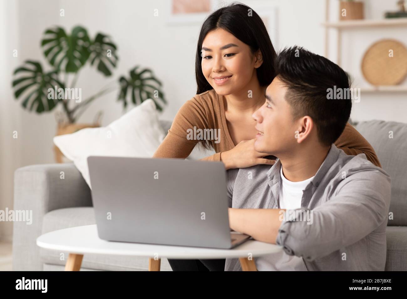 Young filipino couple using laptop at home Stock Photo - Alamy