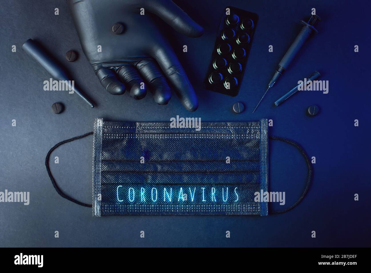 A switch on the virus. Hand in glove, mask, tablets, syringe, vials lie ...