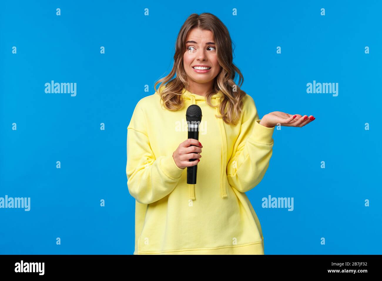 Awkward cute blond girl dont know lyrics as singing karaoke, looking at ...