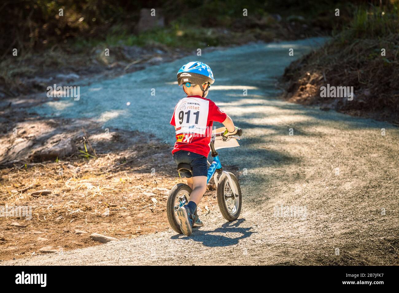 2-3 year old kid on kick-bike, with sunglasses and helmet, at a bike ...