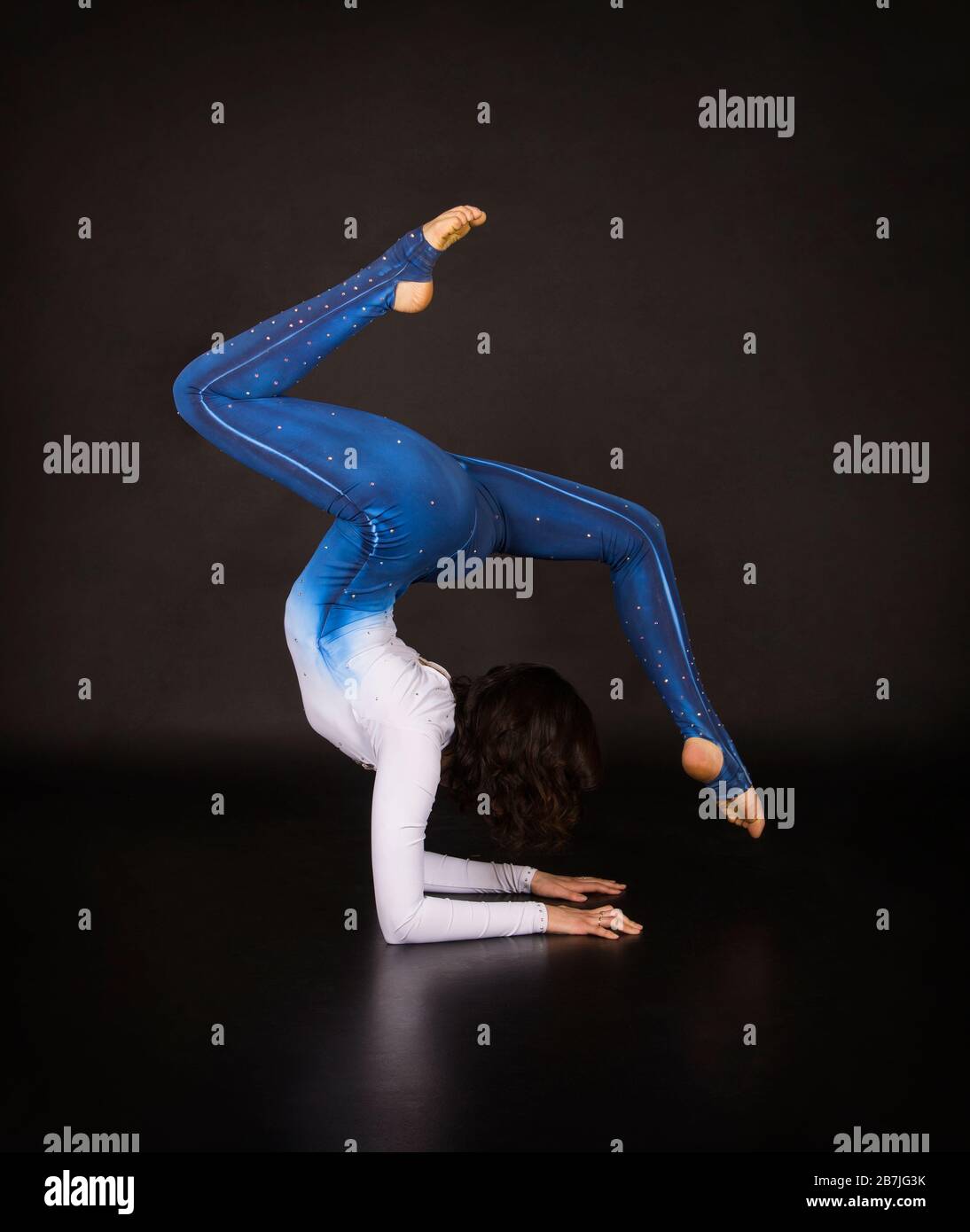 woman acrobat, gymnastics, a young athlete in a blue and white suit ...
