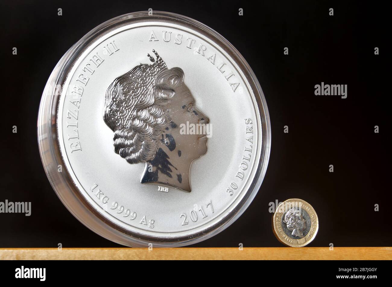 Large 1KG silver coin next to pound sterling concept symbol currency ...