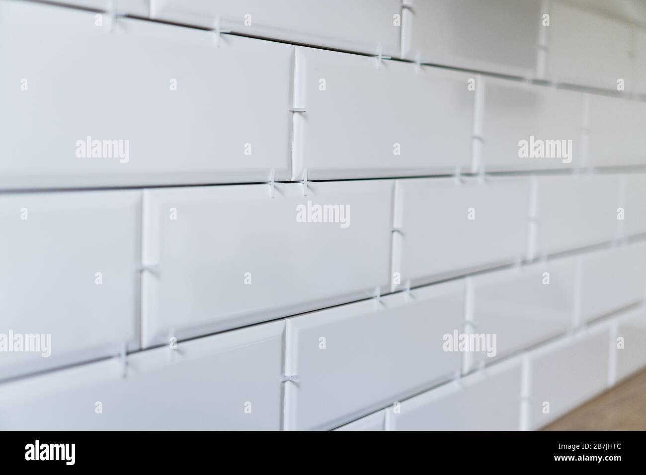 Fitting of white tiles in the kitchen apron Stock Photo - Alamy