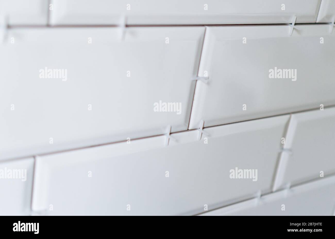 Fitting of white tiles in the kitchen apron Stock Photo - Alamy