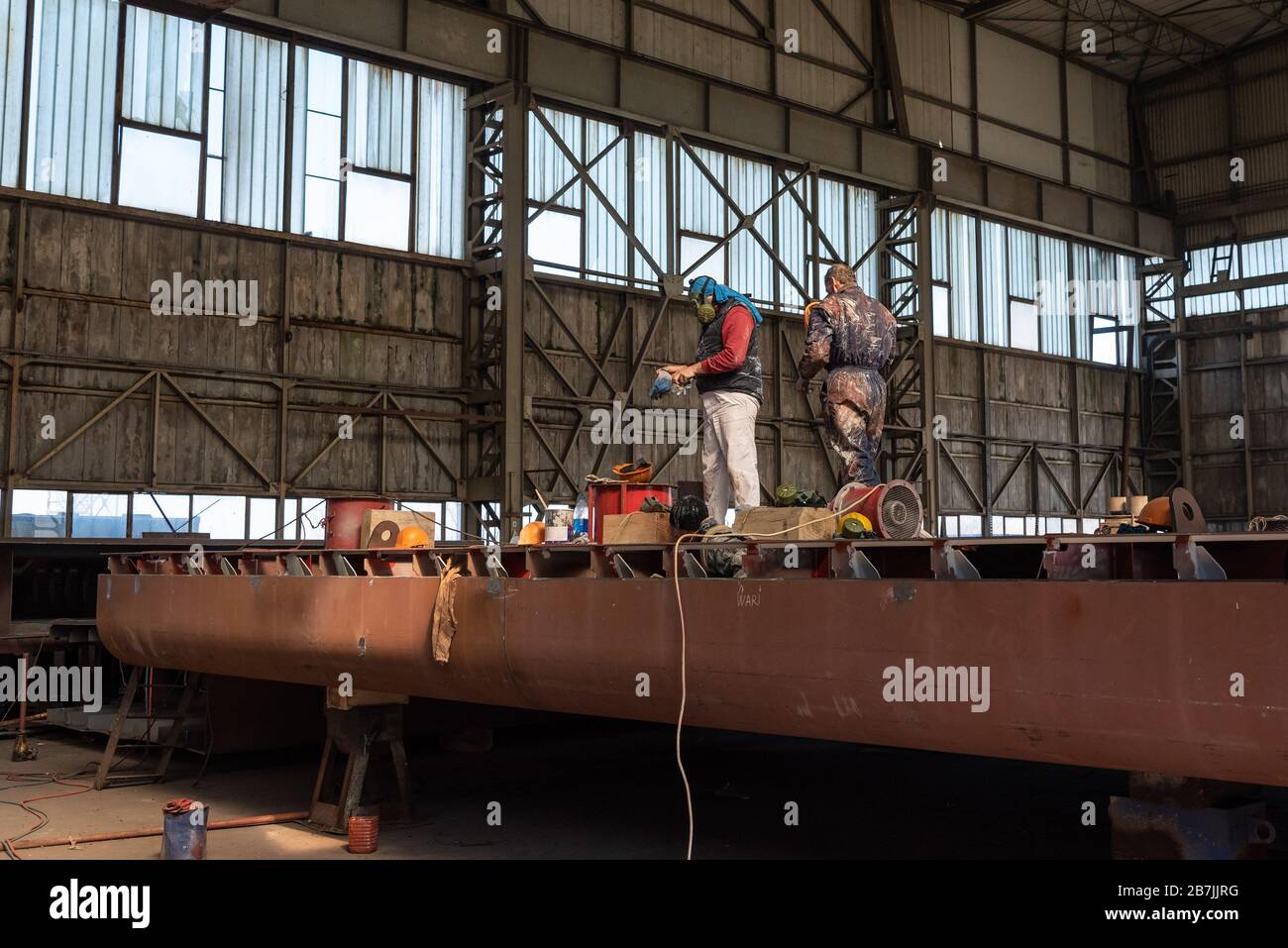 shipyard workers are working in the hangar to build a new ship Stock ...
