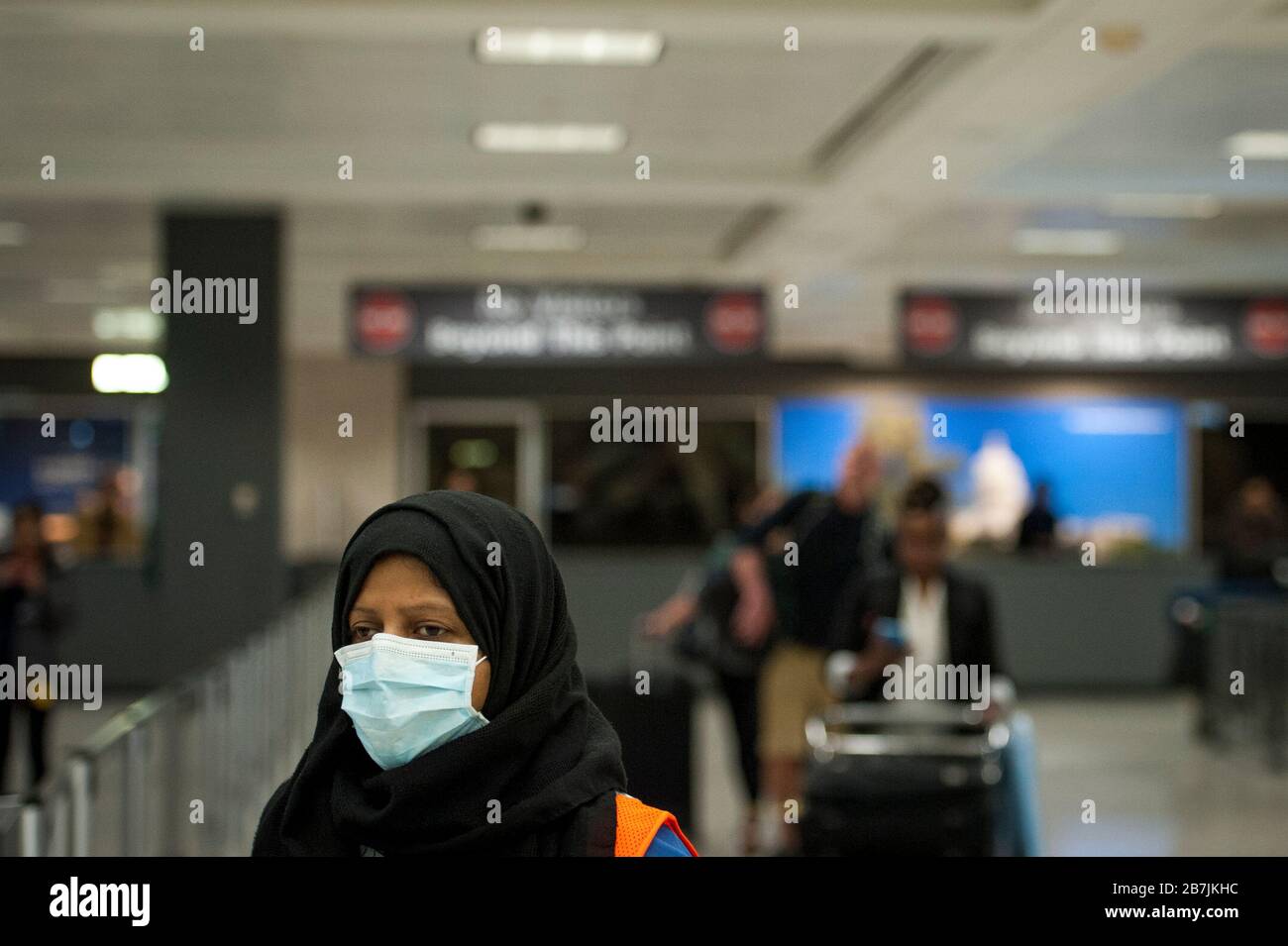 A Dulles International Airport worker assists passengers as they arrive ...